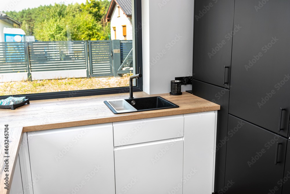 Black sink in a modern kitchen built into the top of kitchen cabinets ...