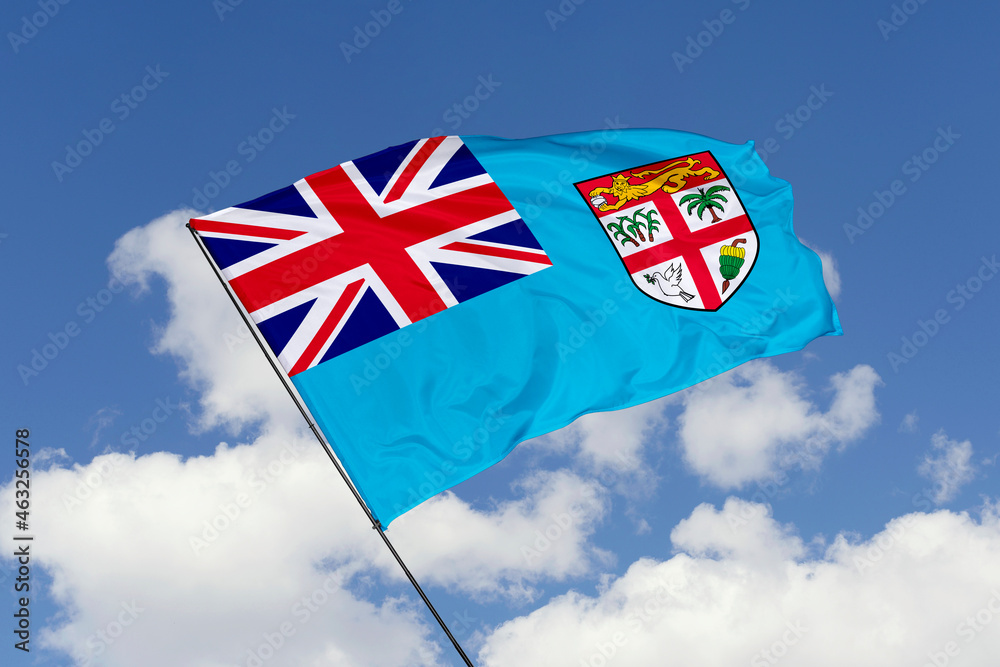 Fiji flag isolated on the blue sky background. close up waving flag of Fiji. flag symbols of ...