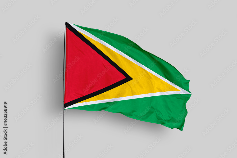 Guyana flag isolated on the blue sky background. close up waving flag of Guyana. flag symbols of ...