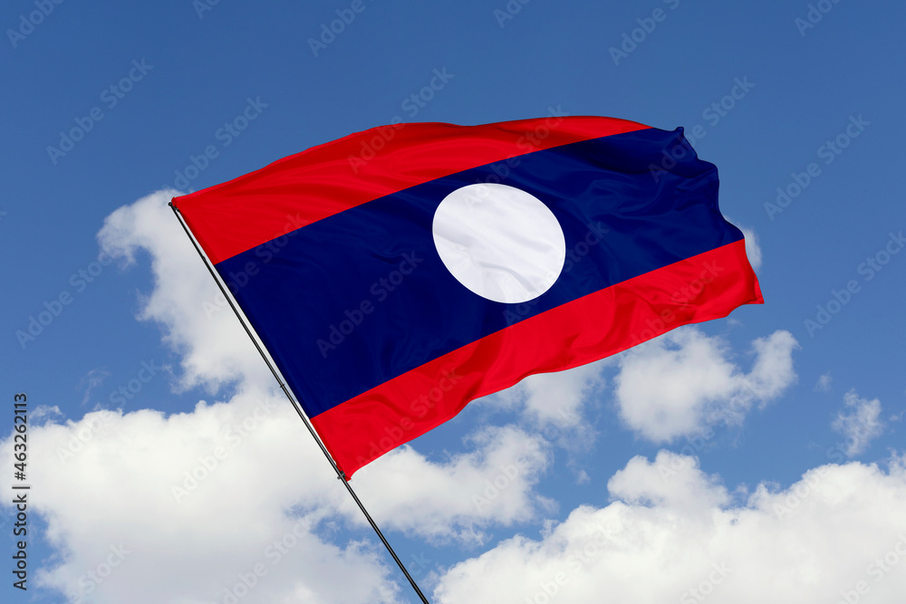 Laos flag isolated on the blue sky background. close up waving flag of ...