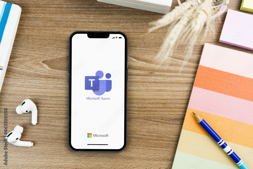 Microsoft Teams app on smartphone iPhone 13 Pro screen on wooden table ...
