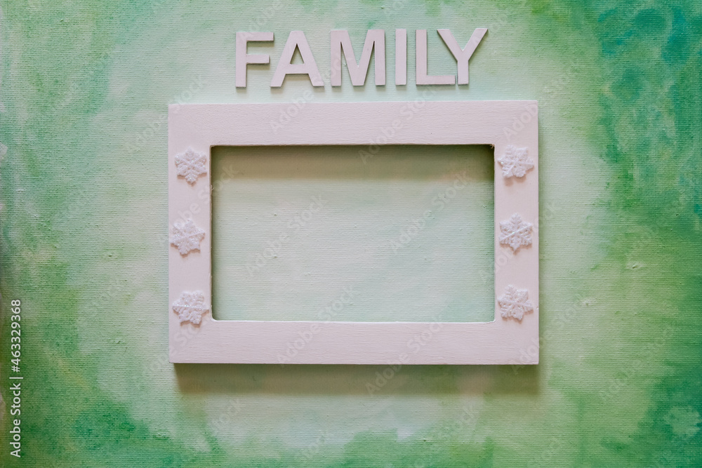 Top down perspective of the word FAMILY above a white picture frame on ...