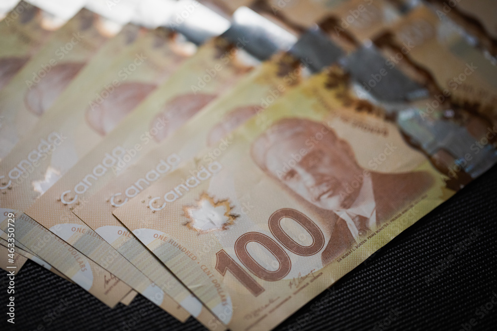 Multiple 100 - hundred Canadian dollar bills on the table. Counting ...