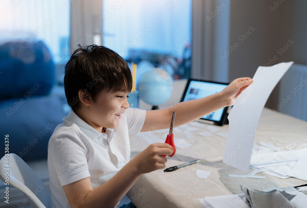 Kid using scissors cutting white paper, schoolboy making art and craft ...
