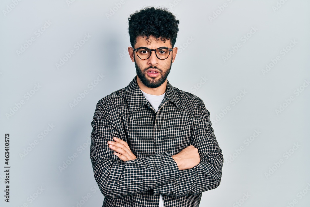 Young arab man with beard wearing glasses with arms crossed gesture in ...