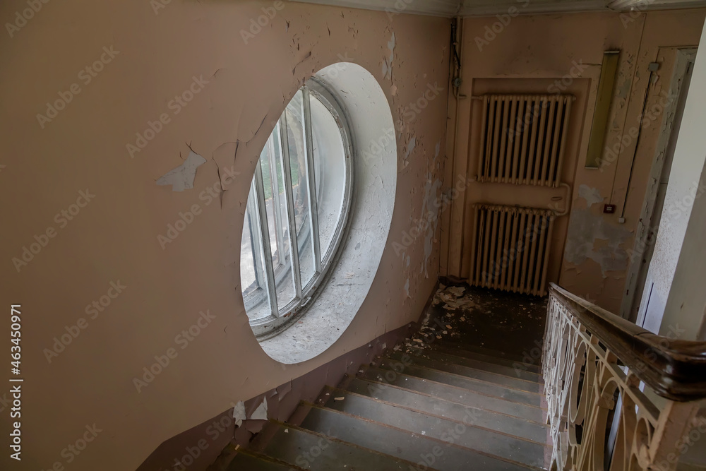 A beautiful round window in an old abandoned hospital. Ancient ...