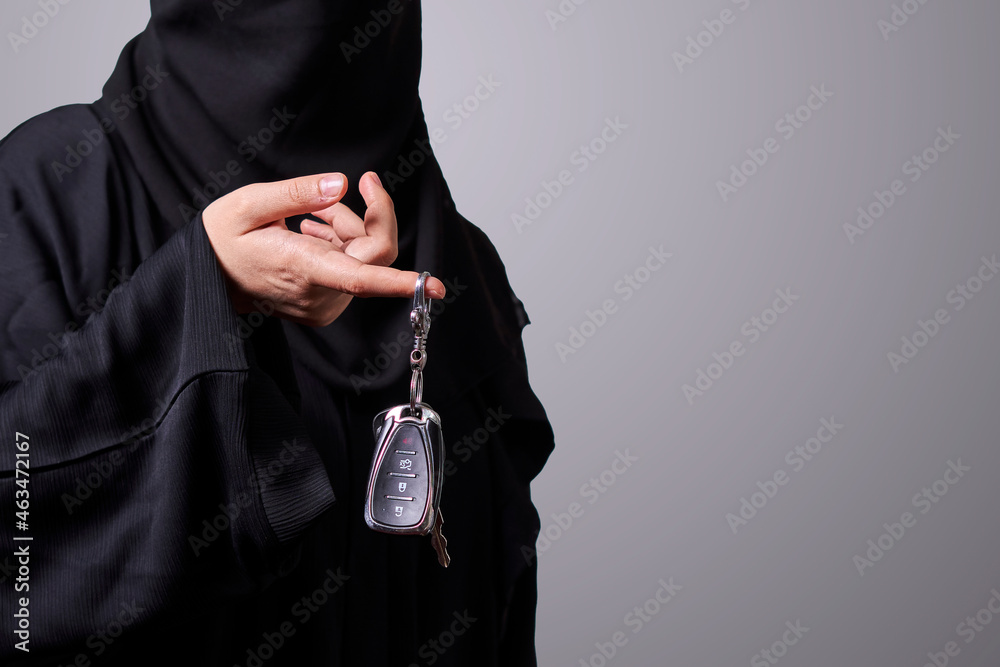 Arabian woman holding car keys. Muslim woman in black traditional ...