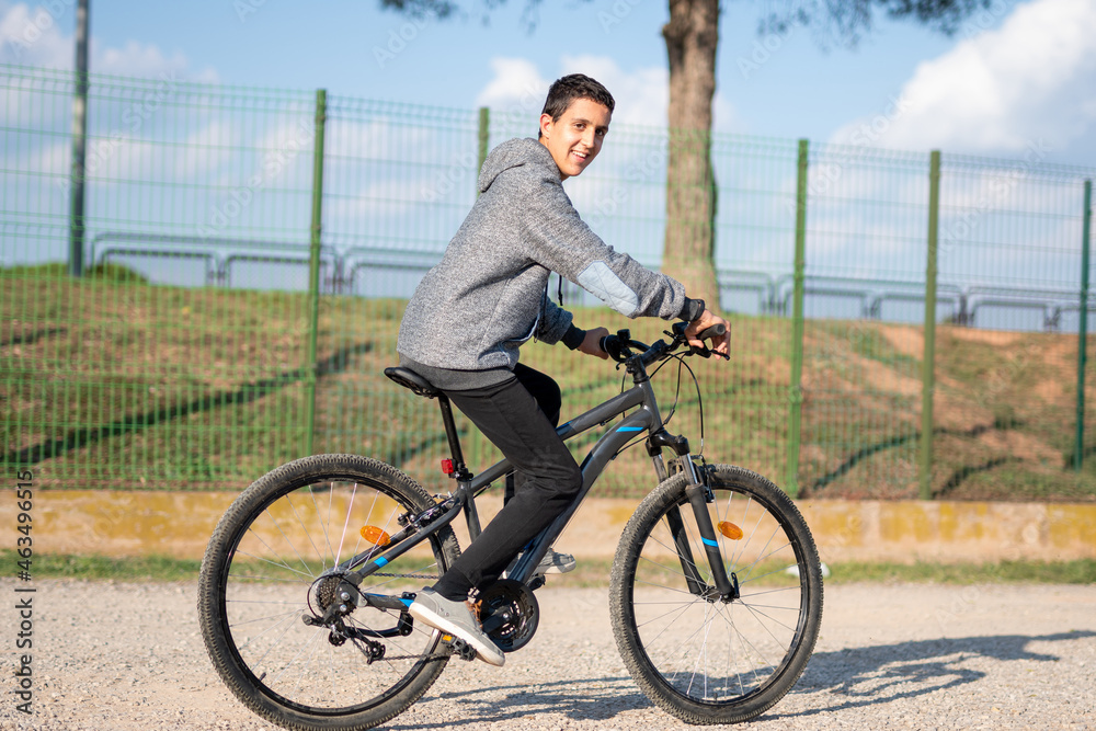 latin teenage boy with dark hair riding a bike Stock Photo | Adobe Stock
