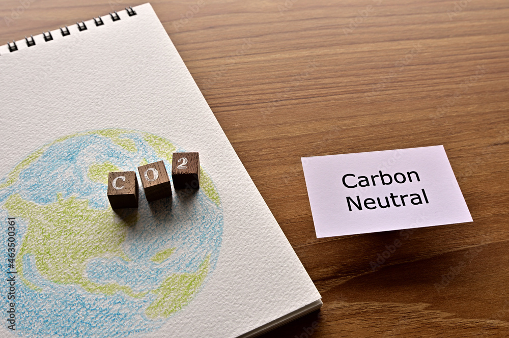 A card labeled "Carbon Neutral" sits on top of a sketchbook with an ...