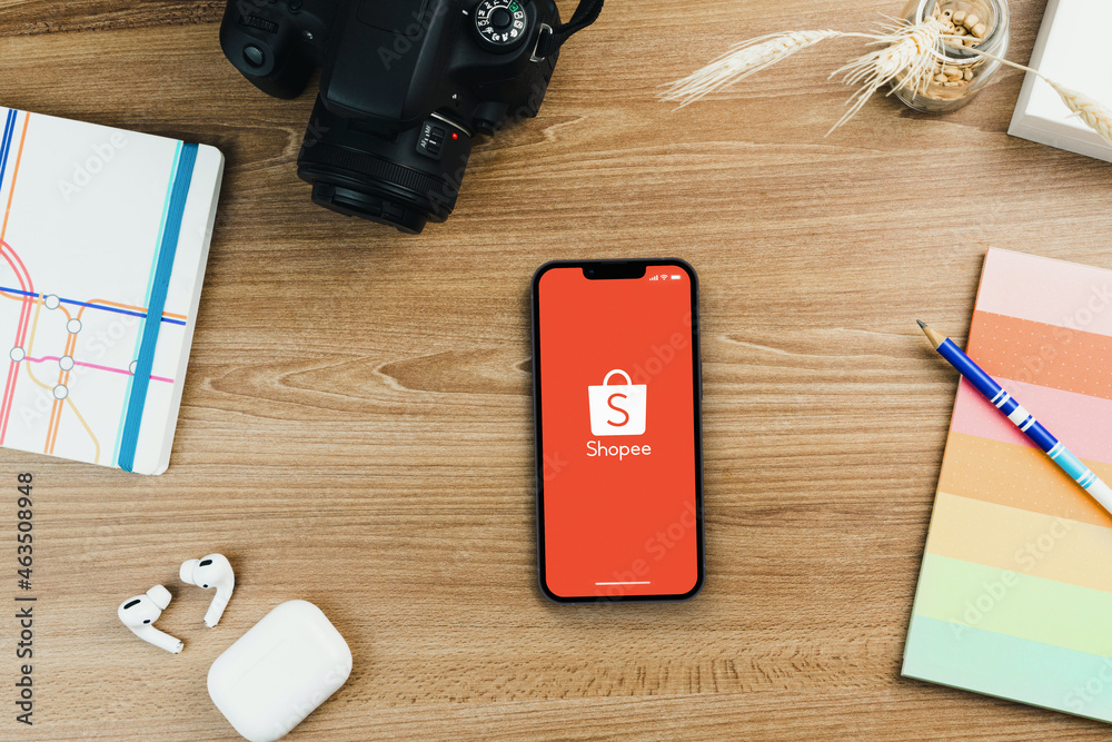 Shopee app on iPhone 13 Pro smartphone screen on wooden table with ...