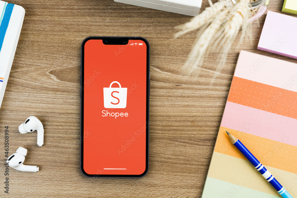 Shopee app on iPhone 13 Pro smartphone screen on wooden table with ...