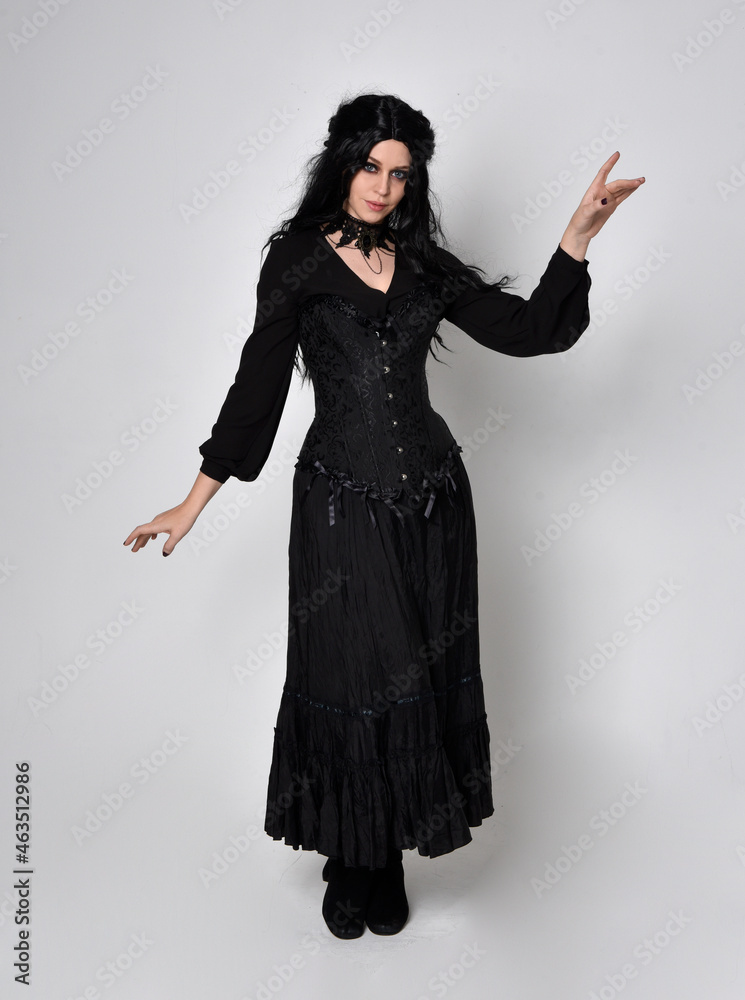 Full length portrait of dark haired woman wearing black victorian witch ...