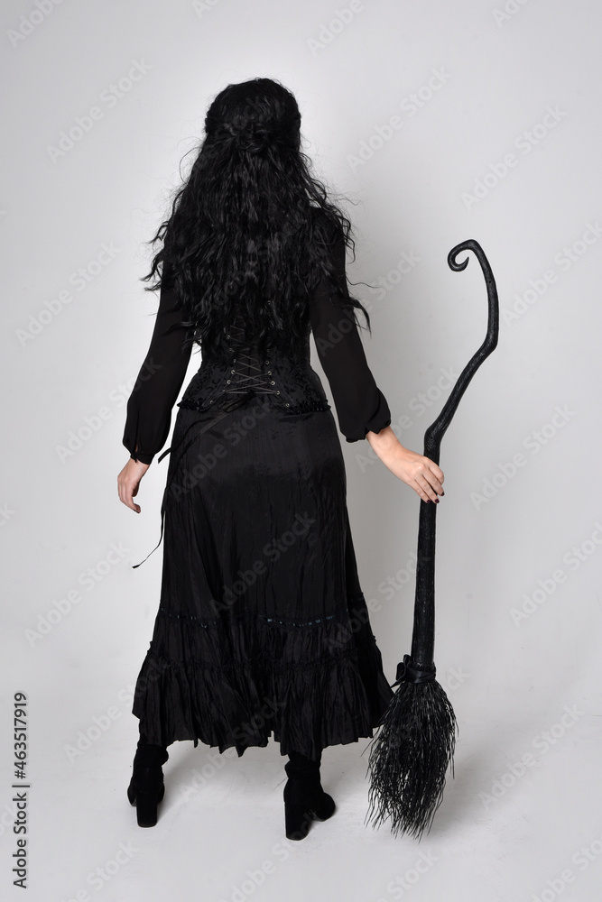 Full length portrait of dark haired woman wearing black victorian witch ...