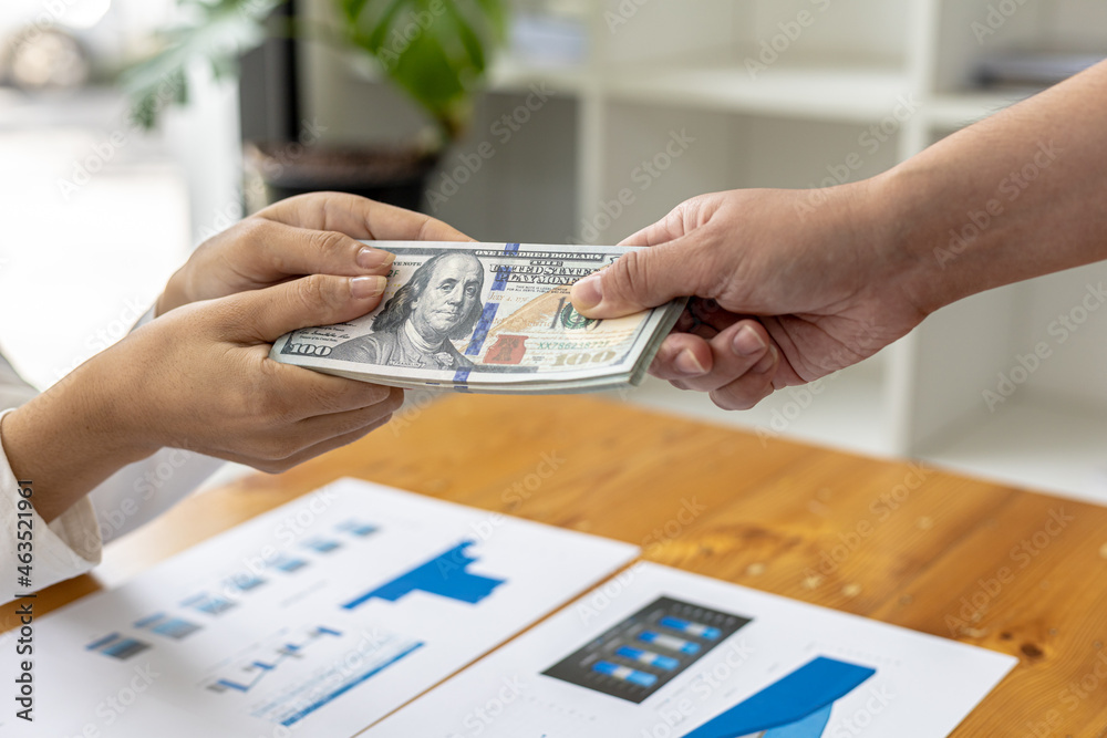 Picture of two people handing over a dollar, they are business partners ...