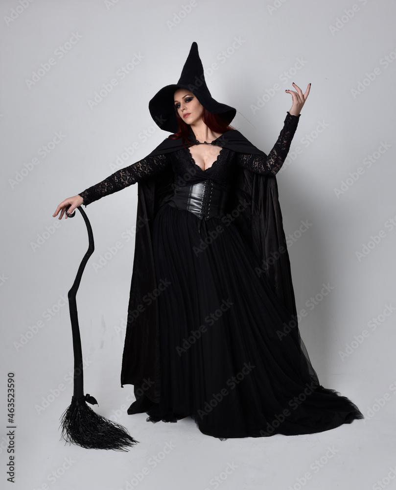 Full length portrait of dark haired woman wearing black victorian witch ...
