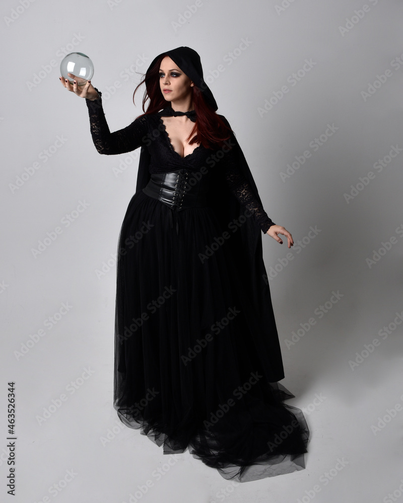 Full length portrait of dark haired woman wearing black victorian witch ...