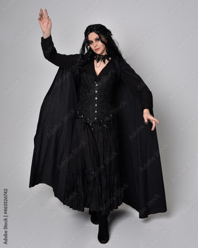 Full length portrait of dark haired woman wearing black victorian witch ...