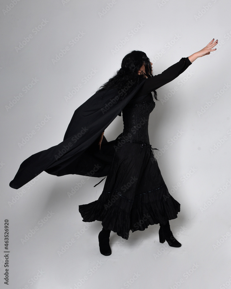 Full length portrait of dark haired woman wearing black victorian witch ...
