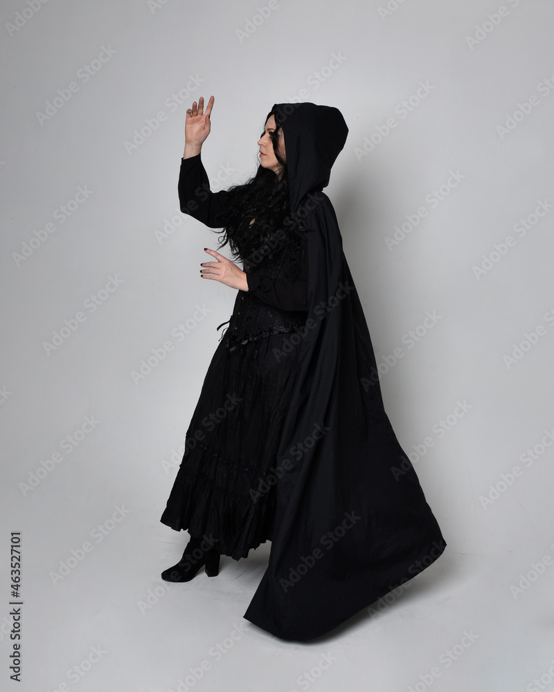 Full length portrait of dark haired woman wearing black victorian witch ...