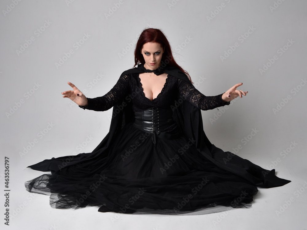 Full length portrait of dark haired woman wearing black victorian witch ...