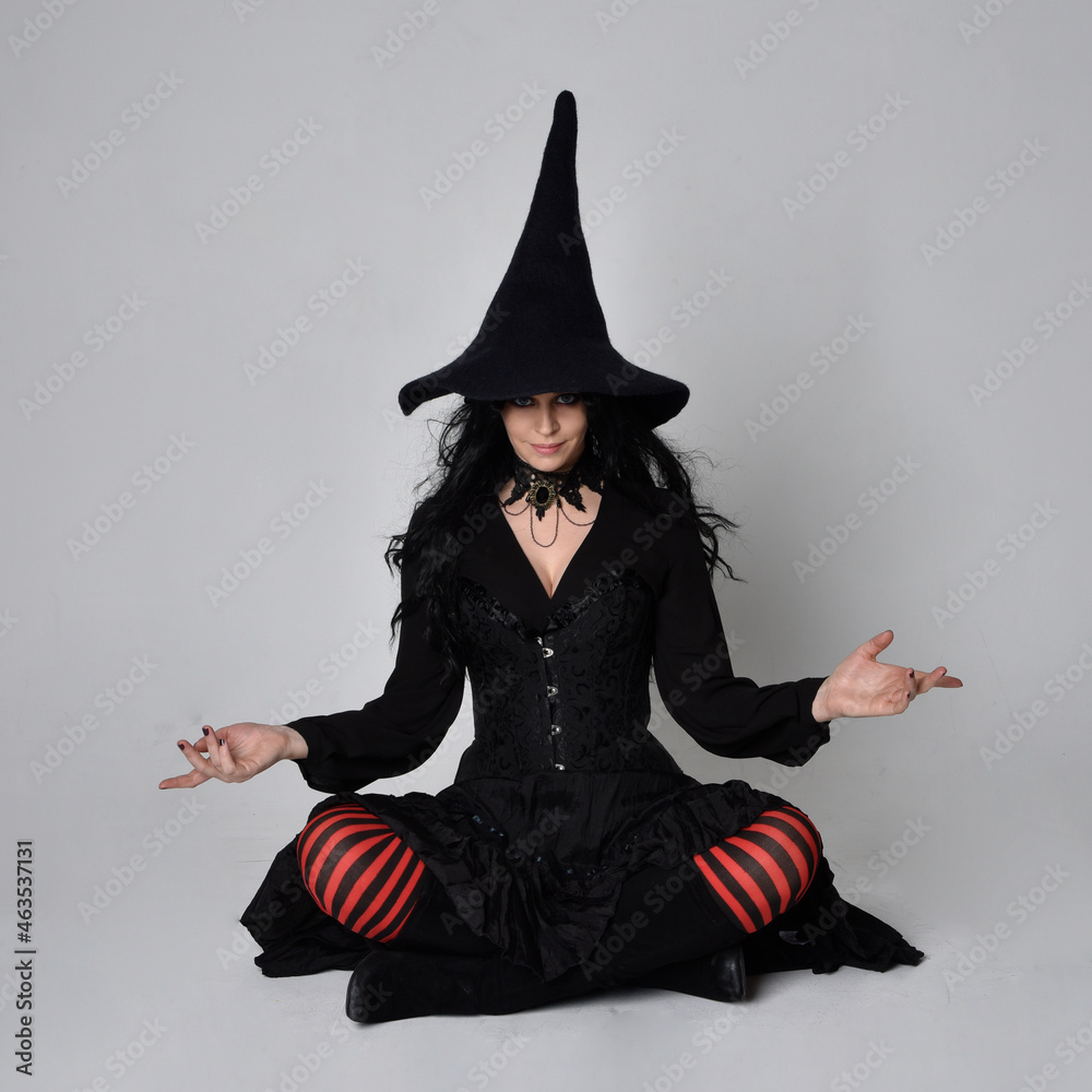 Full length portrait of dark haired woman wearing black victorian witch ...