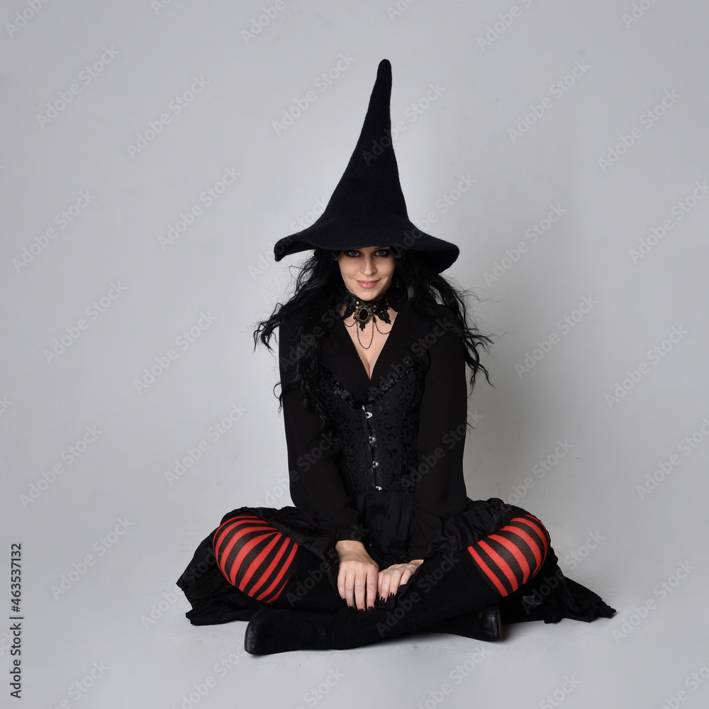 Full length portrait of dark haired woman wearing black victorian witch ...