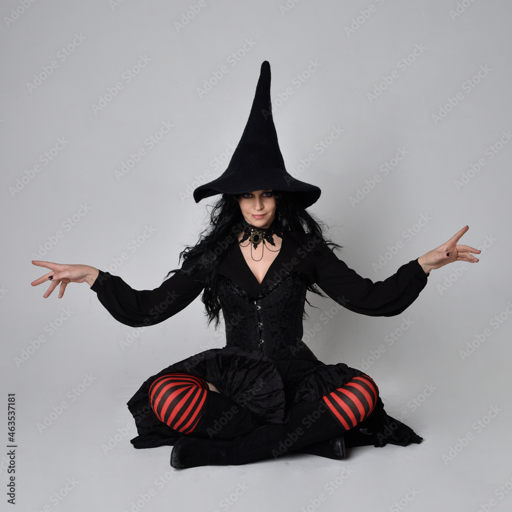 Full length portrait of dark haired woman wearing black victorian witch ...