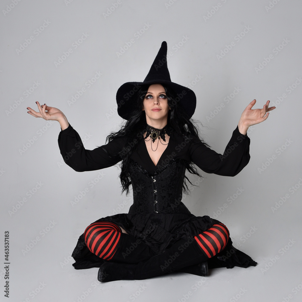 Full length portrait of dark haired woman wearing black victorian witch ...