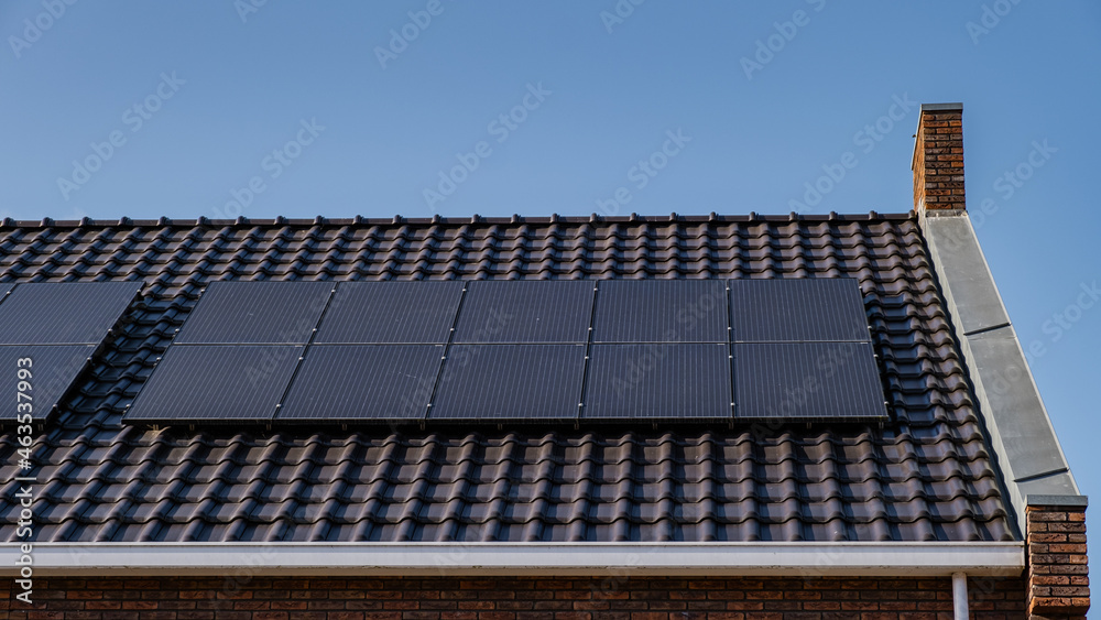 Newly build houses with solar panels attached on the roof against a ...