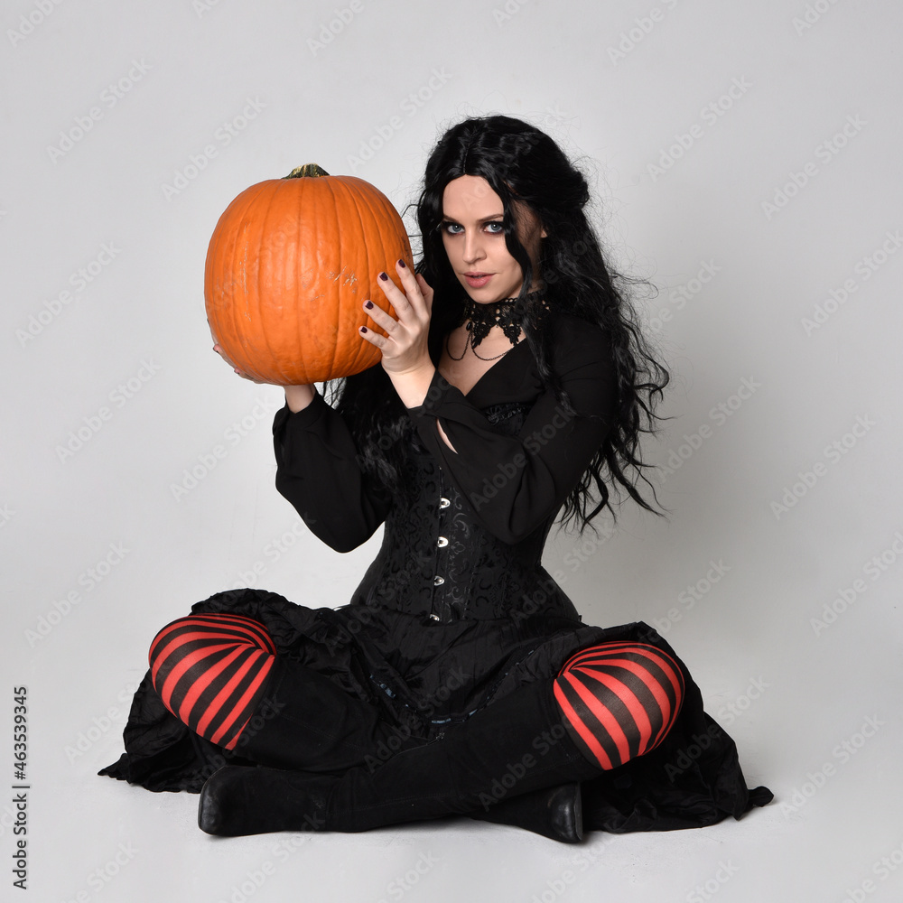 Full length portrait of dark haired woman wearing black victorian witch ...