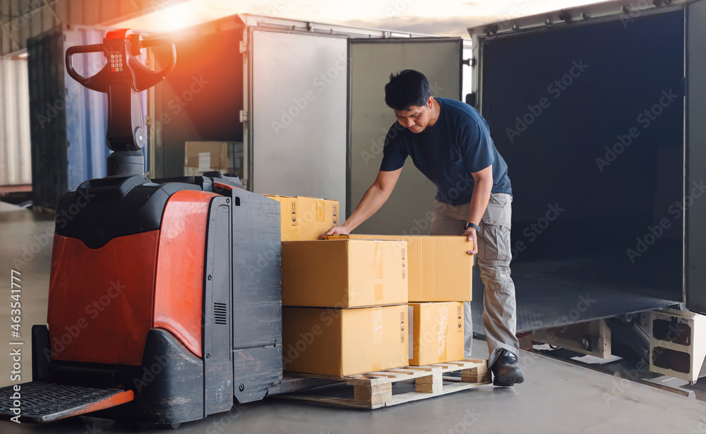 Worker Courier Lifting Packaging Boxes on Pallet. Cargo Loading at Dock ...