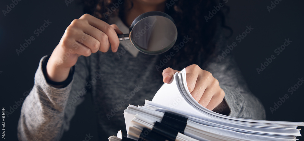 woman holding magnifying glass and documents Stock Photo | Adobe Stock