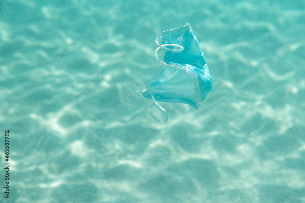 Ocean pollution. Personal protective mask floats underwater ...