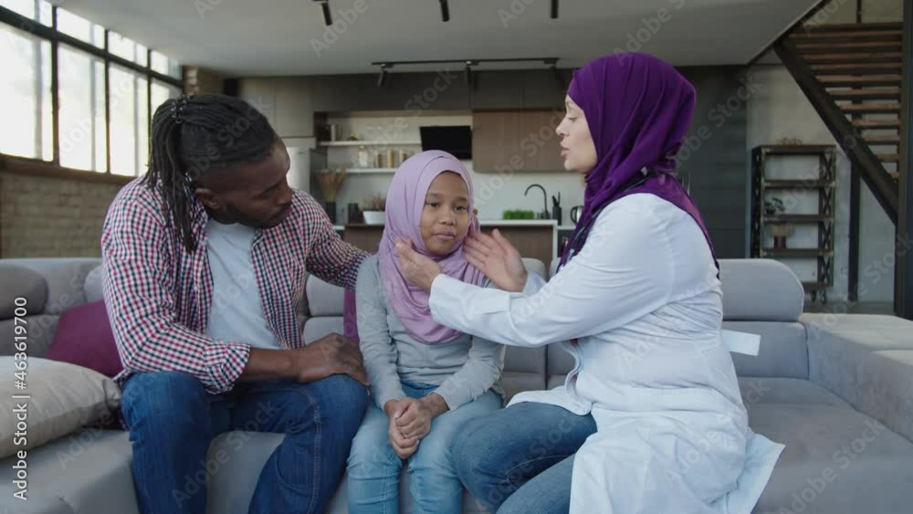Caring arab hijab woman physician in lab coat visiting little patient ...