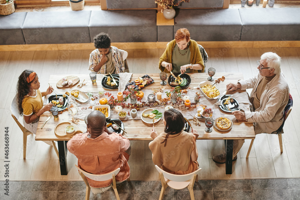 High angle view of big family sitting at dining table and having dinner ...