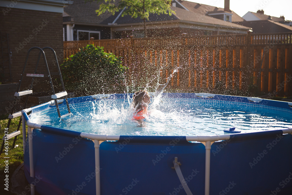 Young girl jumps into backyard pool and makes a big splash Stock Photo ...