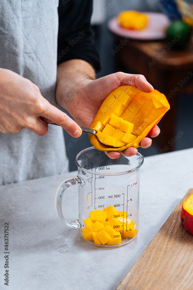 Chef putting cut mango into glass jar Stock Photo | Adobe Stock