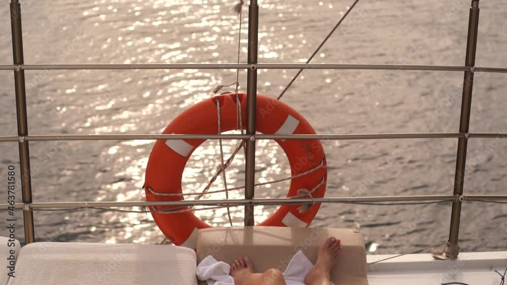 Two pedicured female legs and deck of sailing yacht during excursion ...