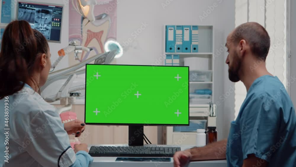 Dentist and man nurse analyzing green screen on computer while looking ...