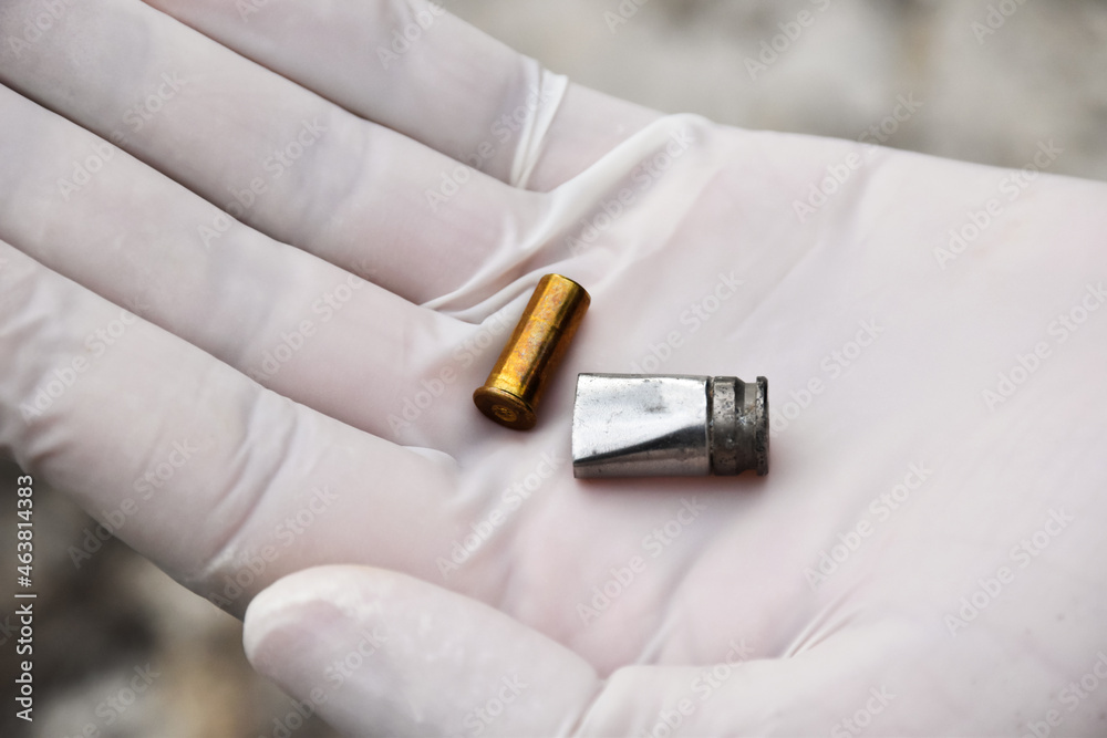 Pistol's bullet shells in palm of investigator or police officer ...