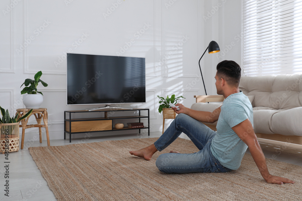 Man watching television at home. Living room interior with TV on stand ...