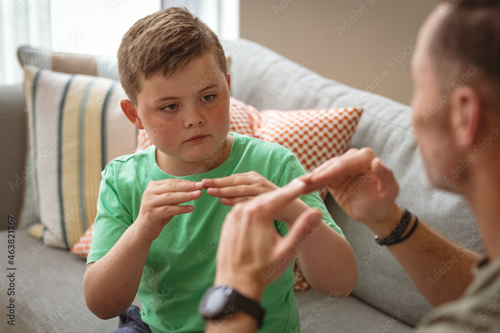 Caucasian father and son communicating using sign language while ...