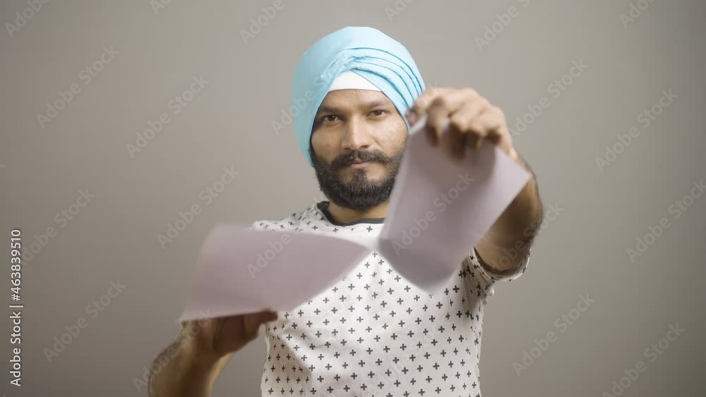 Frustrated angry sikh man tearing and throwing papers by looking camera ...