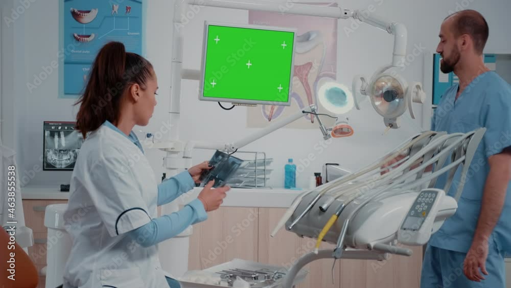 Stomatologist watching monitor with horizontal green screen while ...