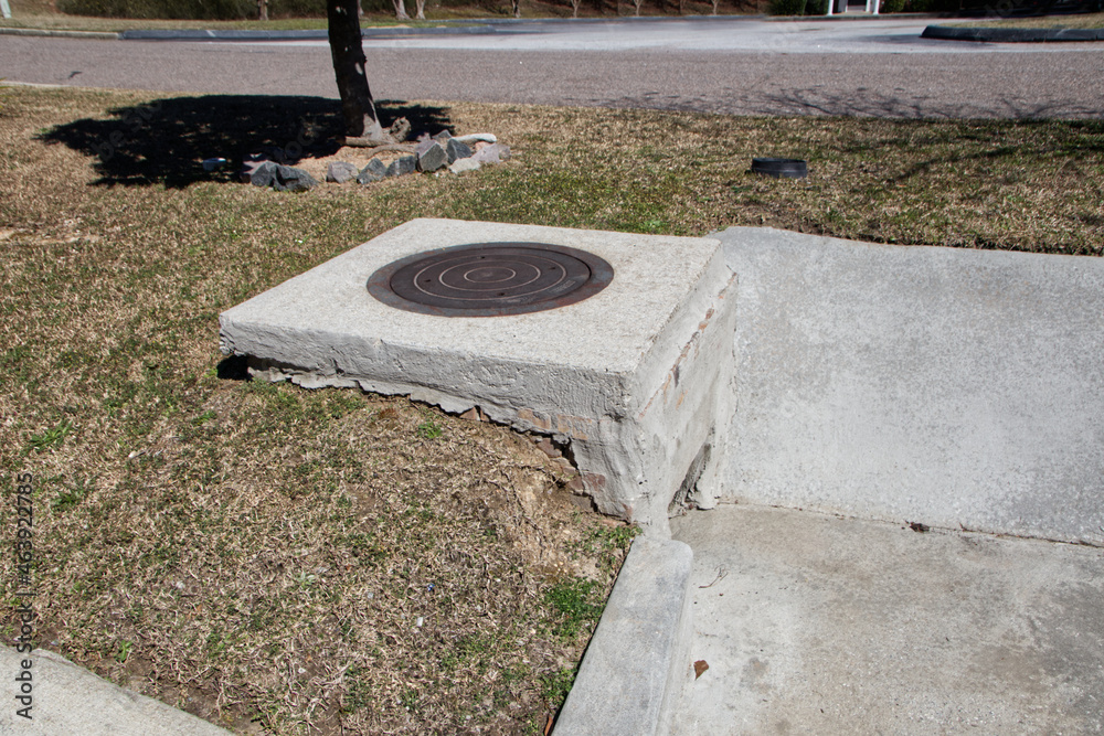 A manhole with cover on a square concrete slab Stock Photo | Adobe Stock