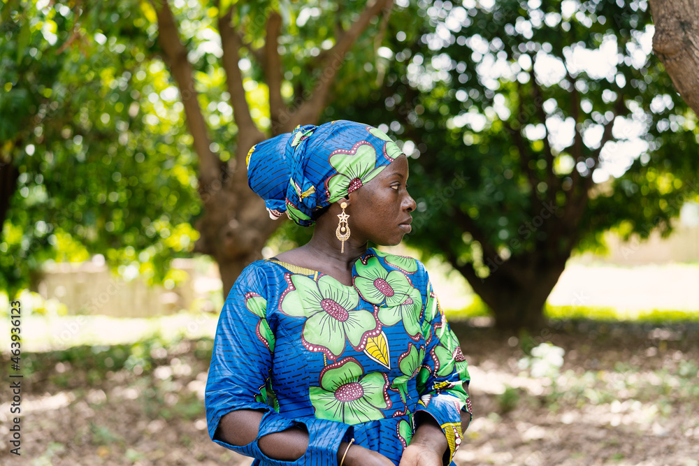 Beautiful black African villager in a colourful traditional dress ...