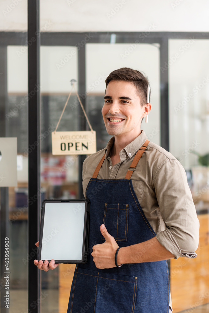 A handsome young man standing next to a sign that reads open in front ...