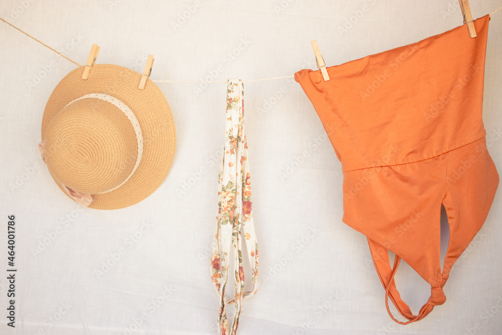 Horizontal image of a hat, a belt and an orange swimming costume on a ...
