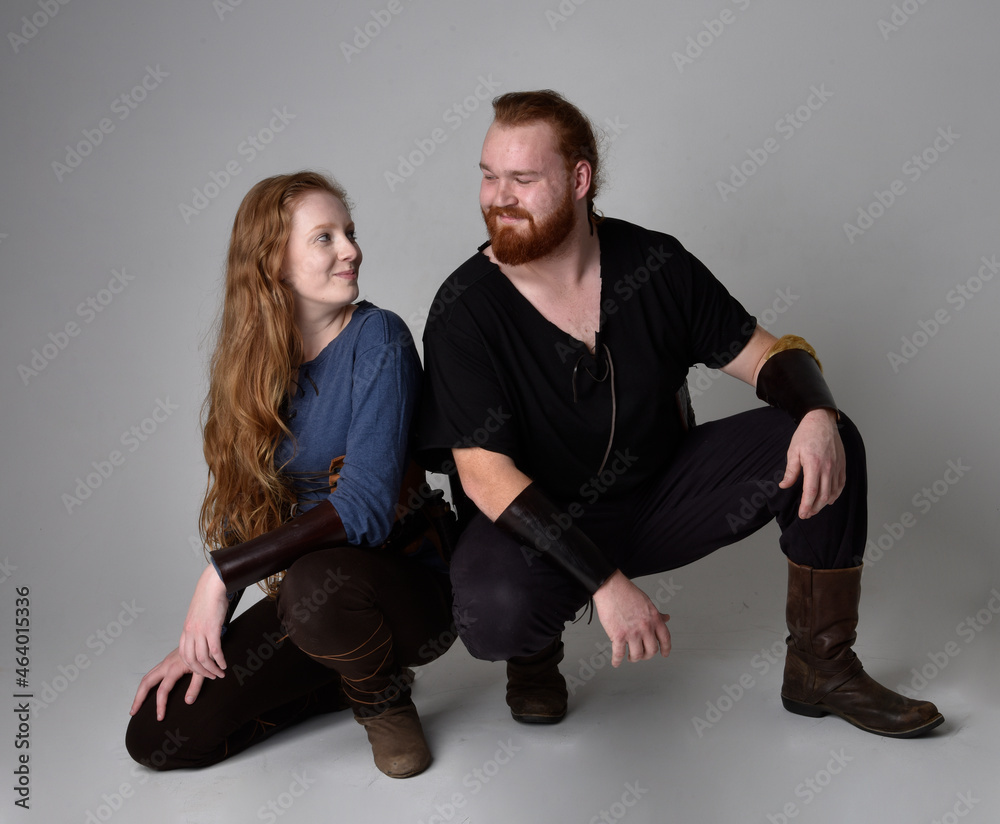 Full length portrait of red haired couple, man and woman wearing ...