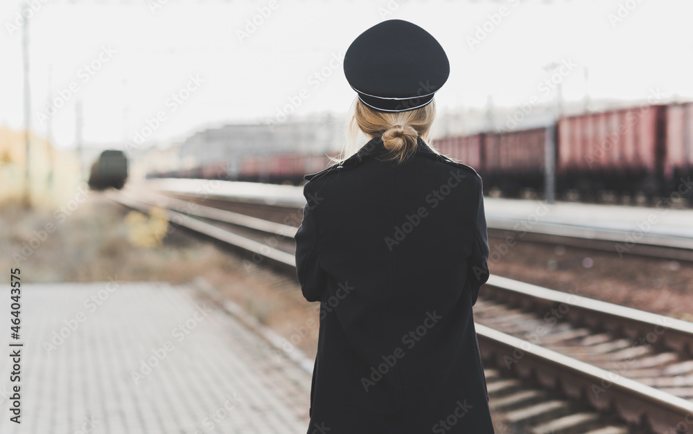 European or American train conductor is on his duty on a platform and ...